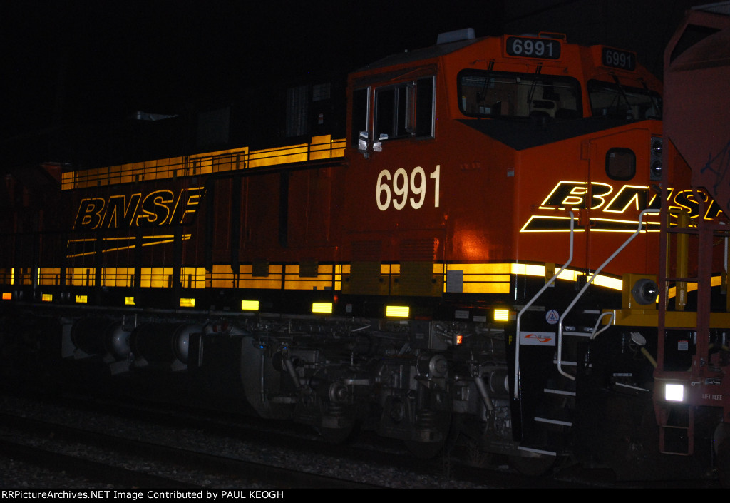 BNSF 6991 Reflects the flash on Her BNSF Reflective Swoosh Logo as she waits for her next Train.